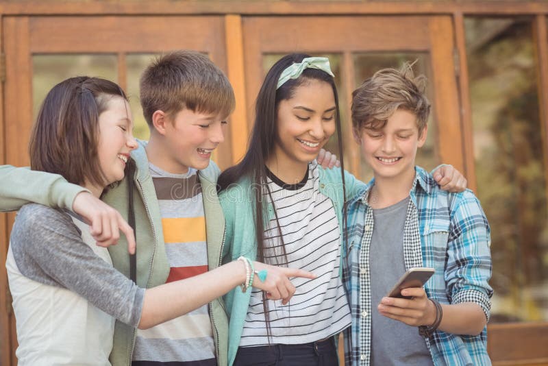 Group of Smiling School Friends Using Mobile Phone Stock Image - Image ...