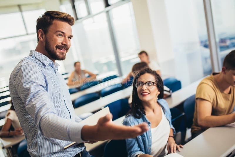 Smiling Students and Teacher with Notebook in Classroom Stock Photo ...
