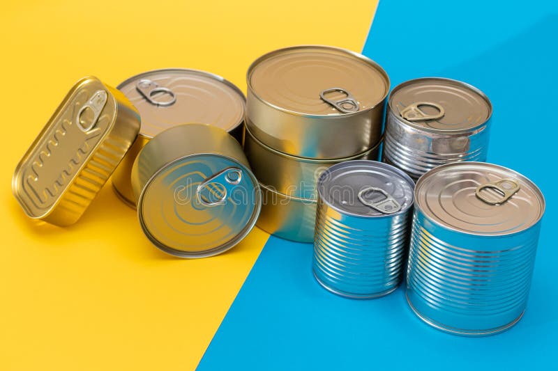 A Group of Stacked Tin Cans on Split Blue and Yellow Background Stock ...