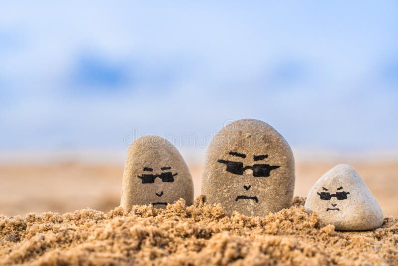 Group of Stones with Drawn Faces in the Sand Stock Image - Image of ...