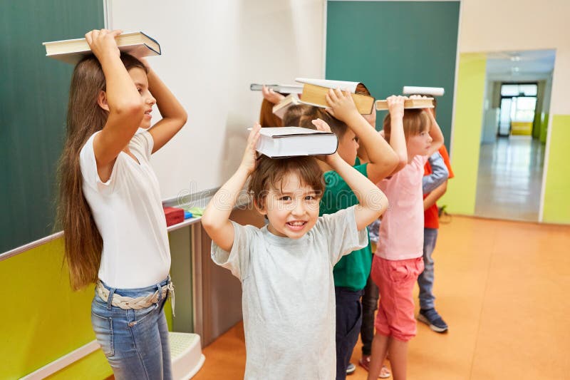 Students Balancing Books Overhead in Class Stock Photo - Image of ...