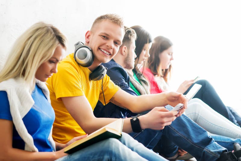 Group of students on a break. Phone, headphones. - Stock Image - Everypixel