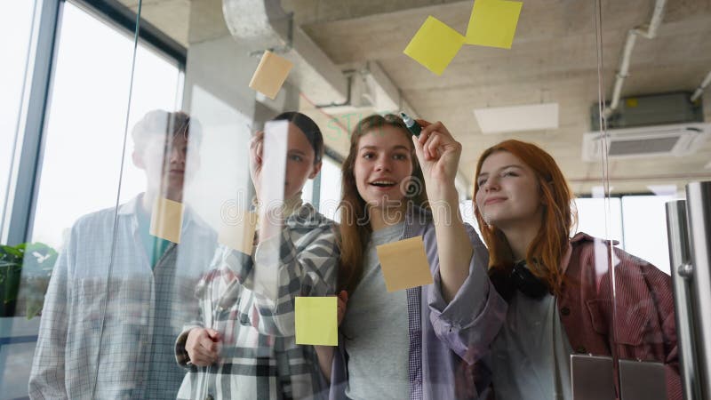A Group of Students Discussing a Study Plan and Standing Behind Glass ...