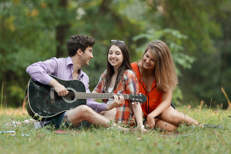 Group of Students with a Guitar Relax Sitting on the Grass in the City ...
