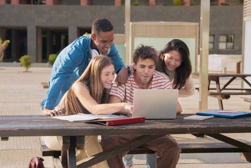A Group of Students with Laptops Sit Near the Campus and Communicate ...