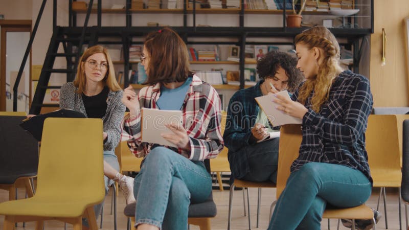 A Group of Students Study and Communicate while Sitting on Chairs in a ...
