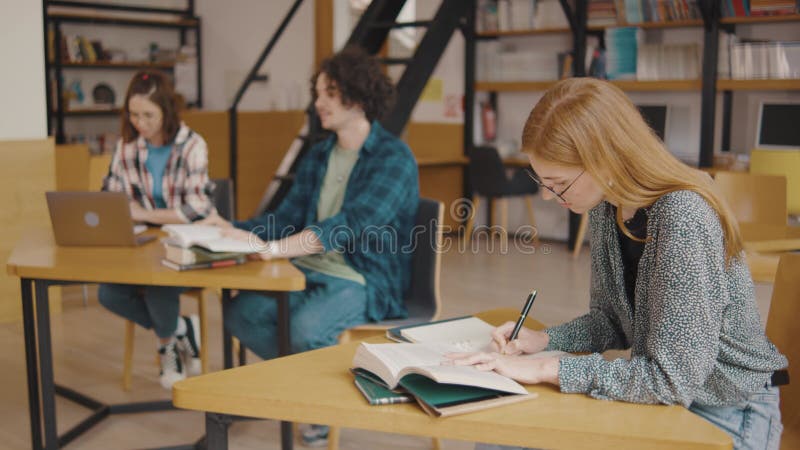 A Group of Students Study and Read Books, Write Information in ...