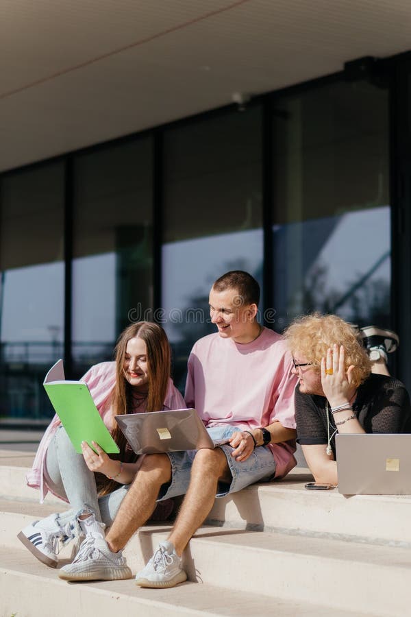 Group of Students Studying and Using Laptops Outside a Modern ...