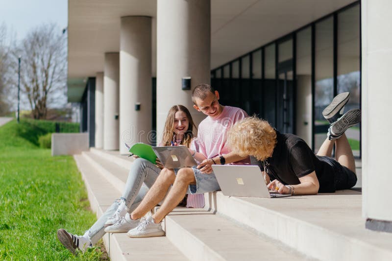 Group of Students Studying and Using Laptops Outside a Modern ...