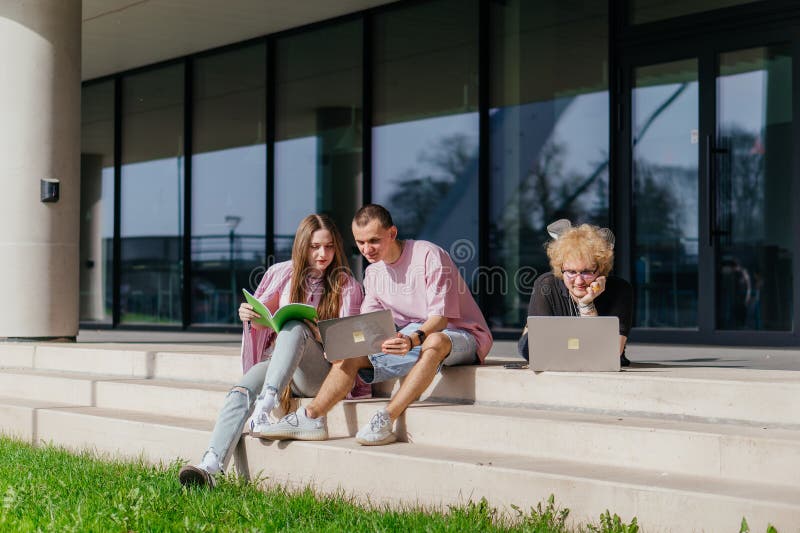 Group of Students Studying and Using Laptops Outside a Modern ...