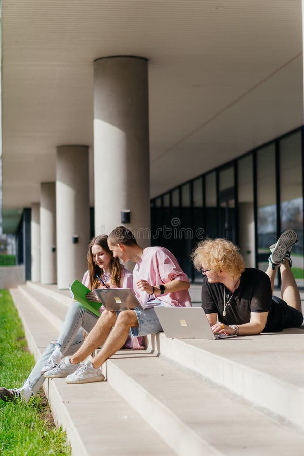 Group of Students Studying and Using Laptops Outside a Modern ...