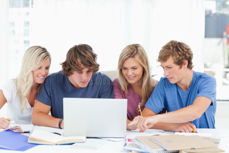 A Group of Students Use a Laptop To Answer Their Questions Stock Photo ...