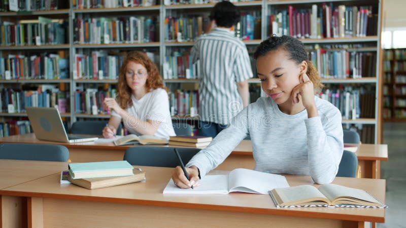 Group of Students Working in Library Reading Books Writing Studying ...