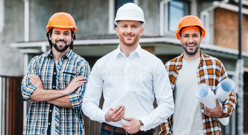 Group of Successful Architects in Hard Hats Looking at Camera in Front ...