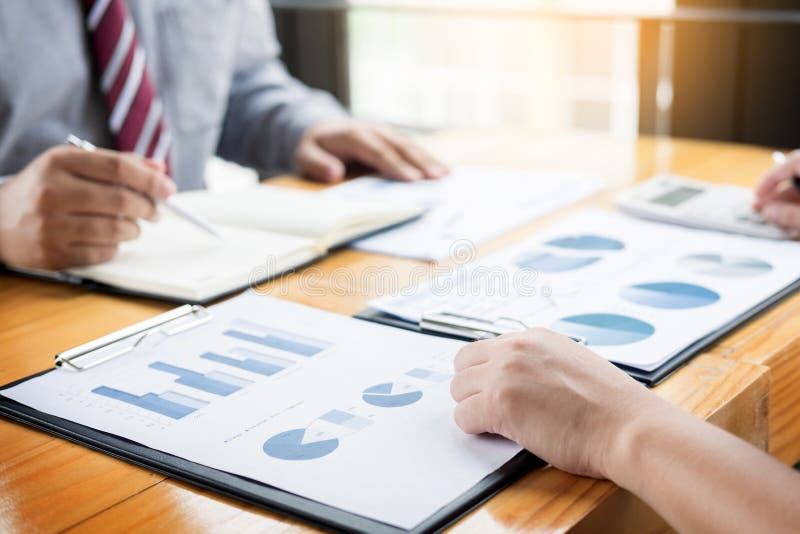 Group of Successful Business People Discussing Paperwork and Using a ...