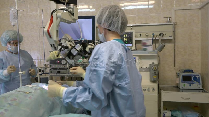 A Group of Surgeons in the Operating Room Perform Microscopic Surgery ...