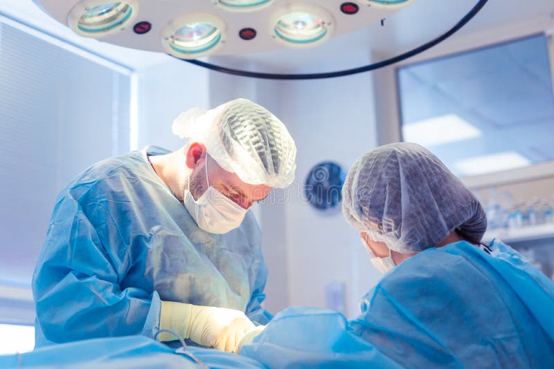 A Group of Surgeons Works in the Operating Room. Two Doctors Perform ...