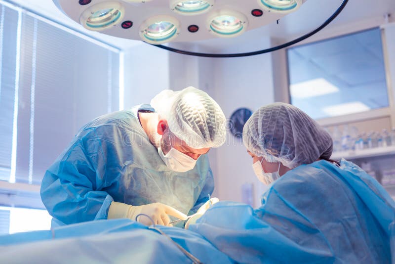 A Group of Surgeons Works in the Operating Room. Two Doctors Perform ...
