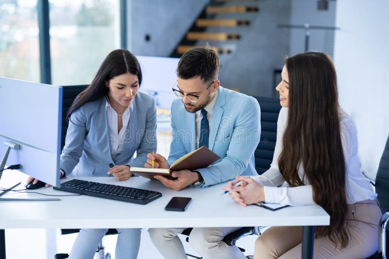 Group of Three Business People Checking Some Notes Together in the ...