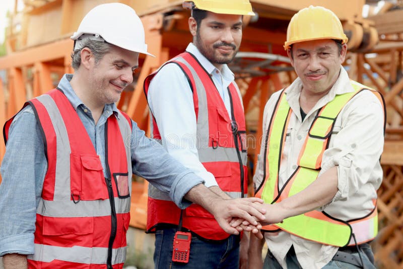 Group of Three Labor Workers with Safety Vest and Helmet Putting Their ...