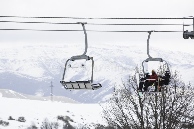 Group of Three People on a Ski Lift with a Mountain Backdrop Editorial ...