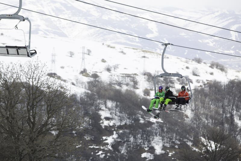 Group of Three People on a Ski Lift with a Mountain Backdrop Editorial ...