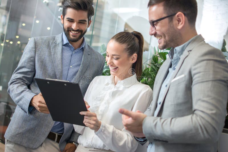 Group of Three Smiling Business People Discussing Documents on Meeting ...