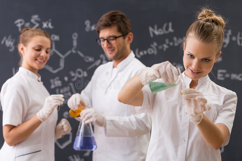 Group of Three Students Conducting an Experiment Stock Image - Image of ...