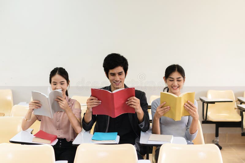 Group of Three Students Reading Book Together in Classroom Stock Photo ...