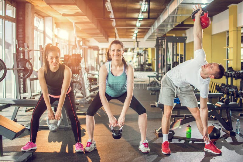 Group of Athletes Doing Strength Exercises on Gym Machines in Fitness ...