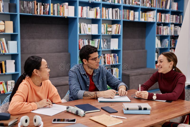 Group of Three Young People Studying Together in Modern College Library ...