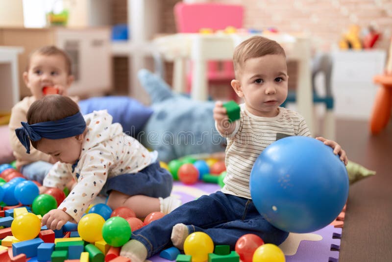 Group of Toddlers Playing with Toys Sitting on Floor at Kindergarten ...