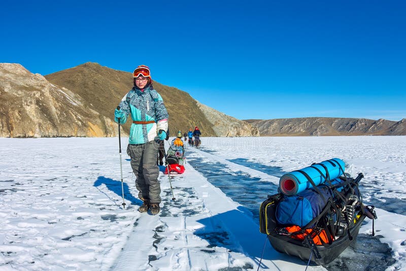 Group of Tourists with Ice Sleds Walking Along the Ice of Lake Baikal ...