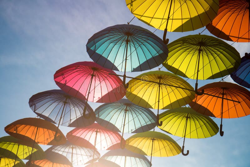 Group of Umbrellas Hanging on a Rope Isolated Against Blue Background ...