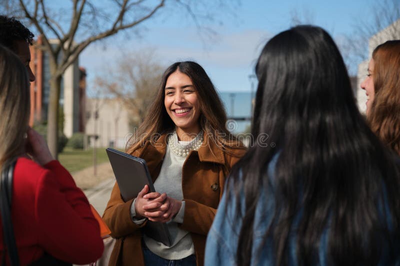University Students Smiling and Talking Outdoors Holding Laptop Stock ...