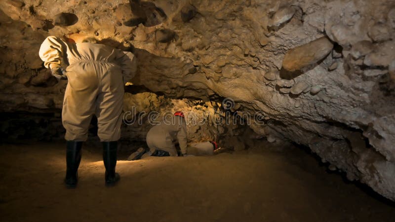 Group of Unrecognizable Spelunkers Crawling Along a Narrow Cave. Stock ...