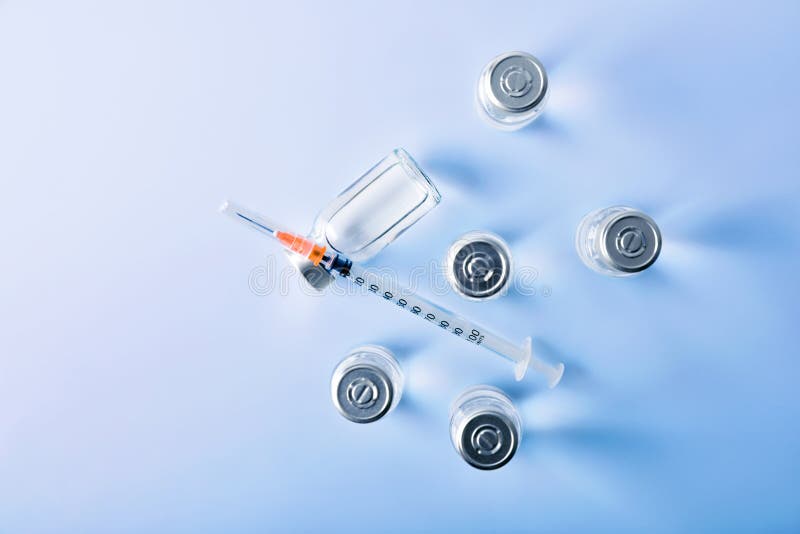 Group of Vials and Syringe on Blue Table Top View Stock Photo - Image ...
