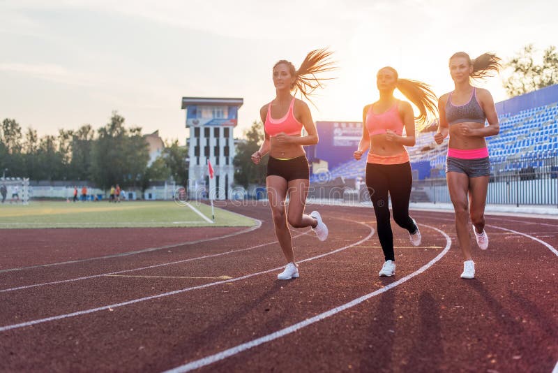 Group of Women Athletes Running Together in Stadium. Stock Photo ...