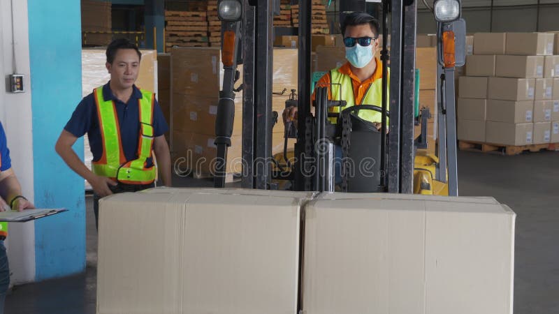 Group Worker and Man Driving Forklift Lift Box or Packaging for ...