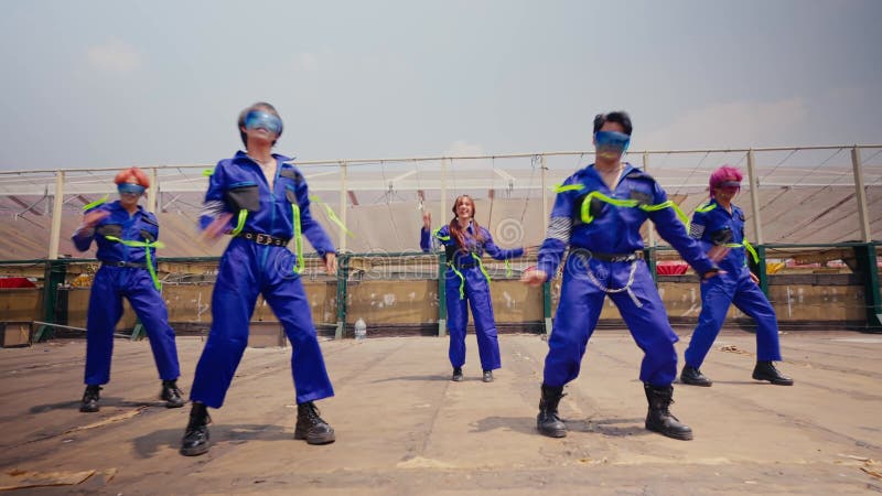 Group of Workers in Blue Uniforms Joyfully Dancing on a Concrete ...