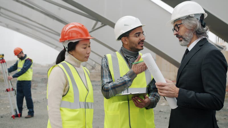Diverse Group of Construction Workers Collaborate on a Construction ...