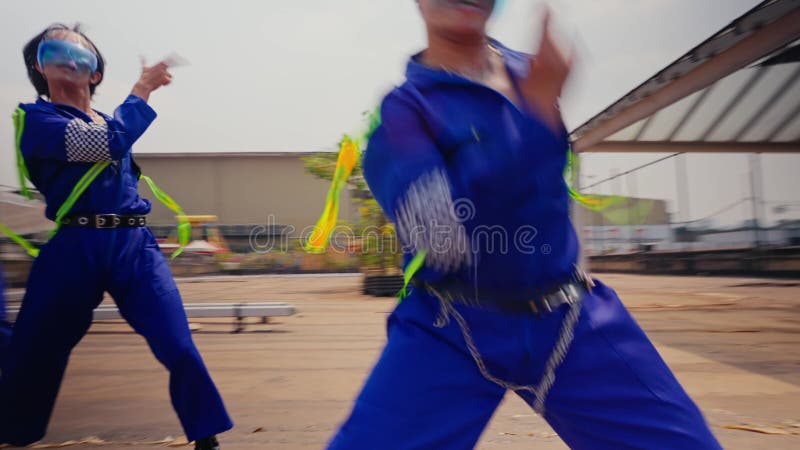 Group of Workers in Uniforms Doing a Coordinated Dance Outdoors Stock ...