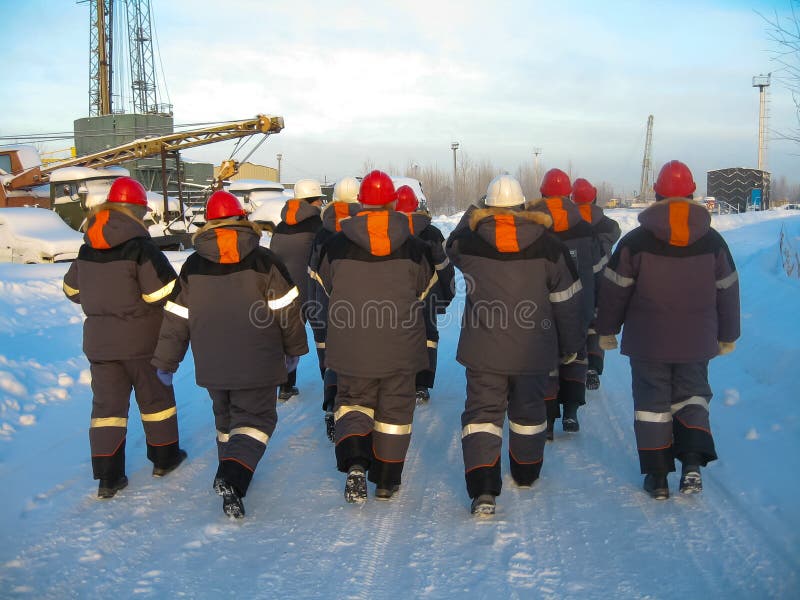 A Group of Workers in Work Clothes and Helmets, Rear View Editorial ...