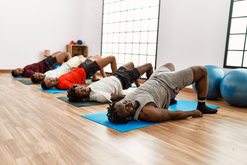 Group of Young African American Man Training Abs Exercise at Sport ...