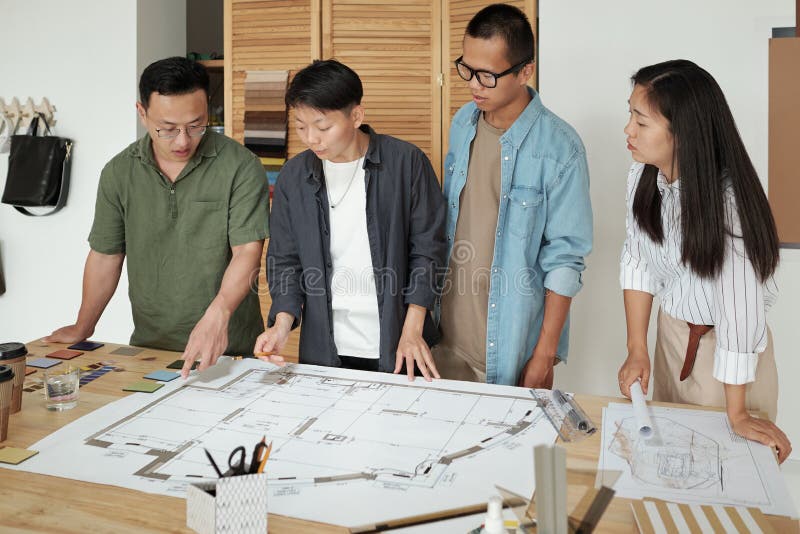 Group of Young Architects Gathered by Table with Large Sketch Stock ...