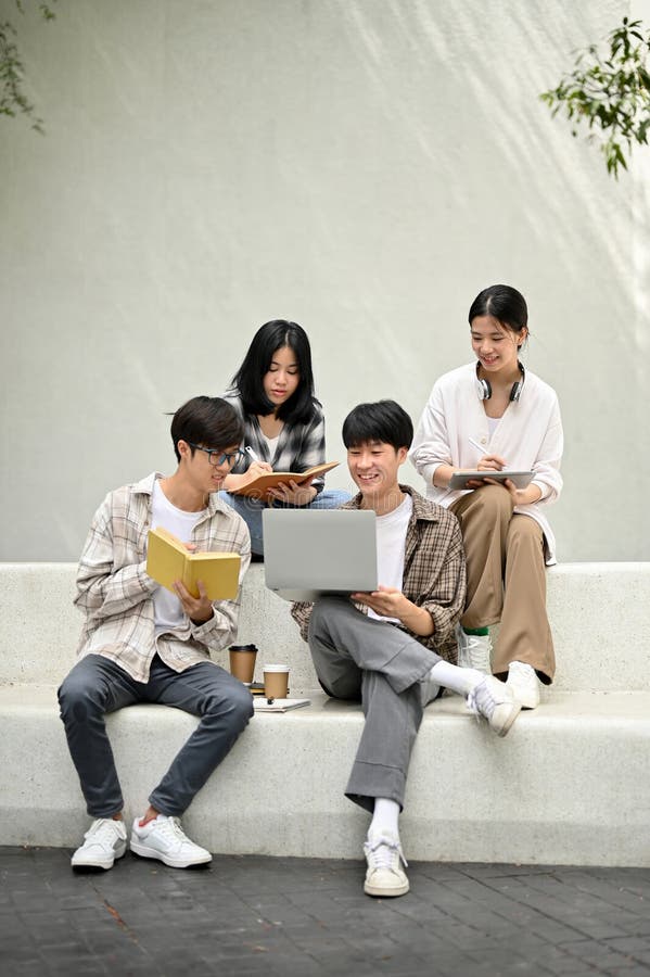 Group of Asian College Students Sitting on a Bench, Doing Homework or ...