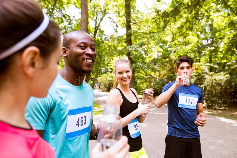 Group of Young Athletes Prepared for Run, Drinking Water. Stock Photo ...