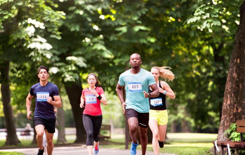 Group of Young Athletes Running in Green Sunny Park. Stock Image ...