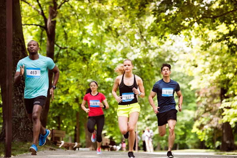 Group of Young Athletes Running in Green Sunny Park. Stock Image ...
