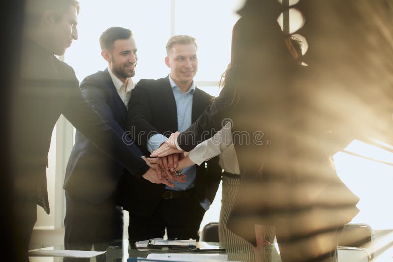 Group of Young Business People Joining Their Palms Over a Work Desk ...